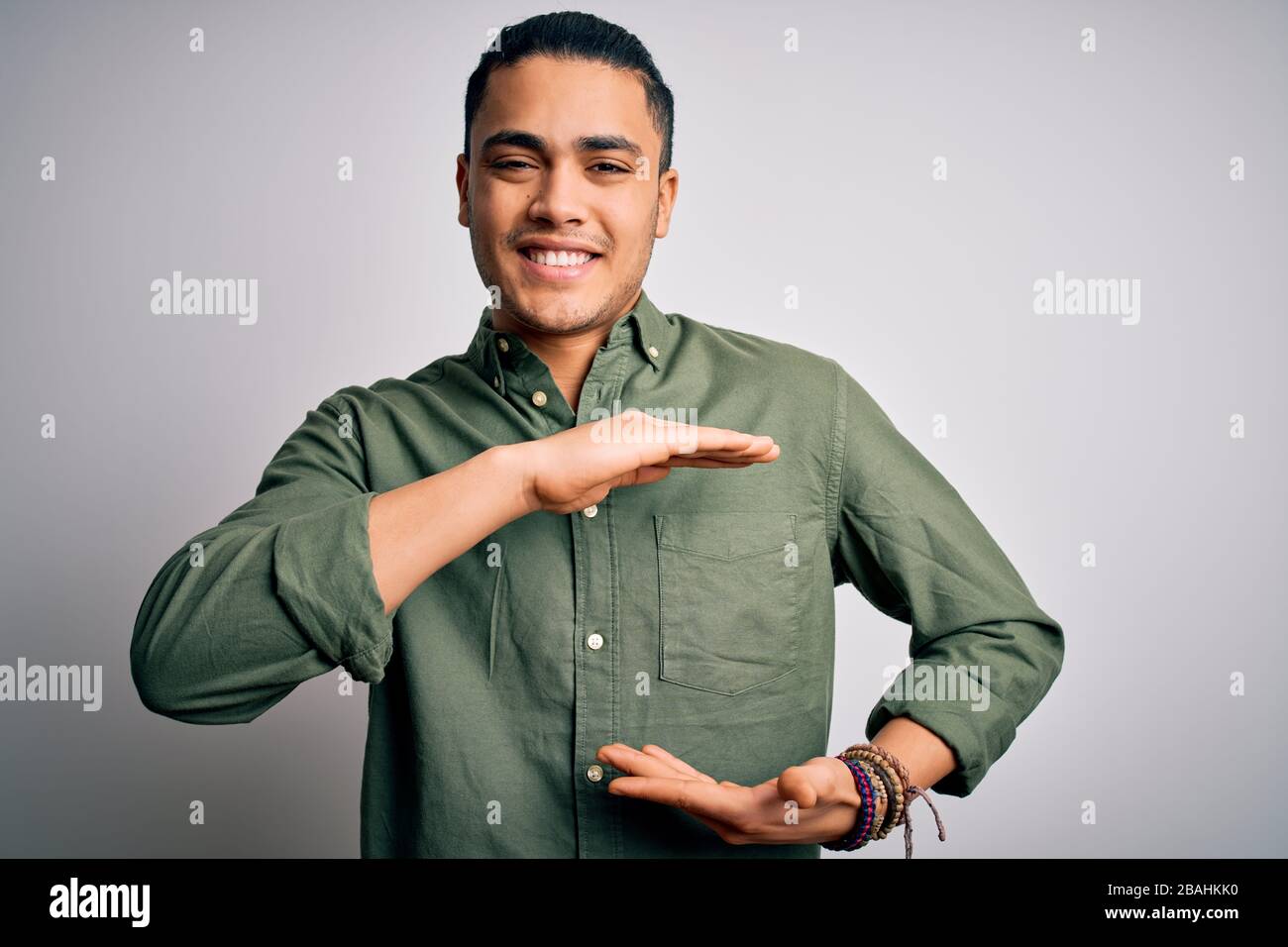 Young brazilian man wearing casual shirt standing over isolated white ...
