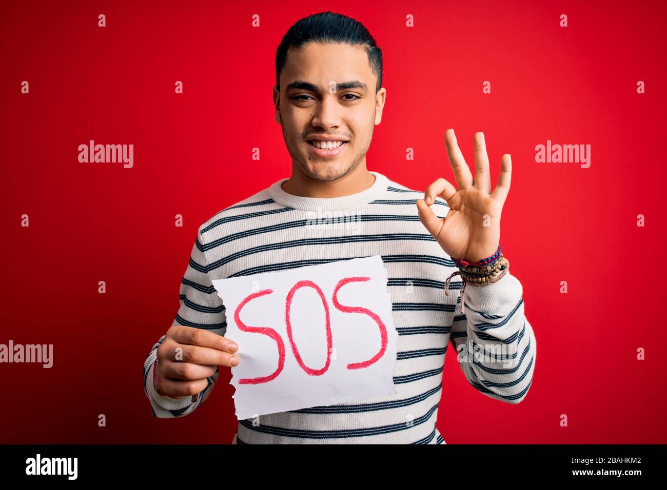 Young brazilian man with problem holding banner with sos message over ...