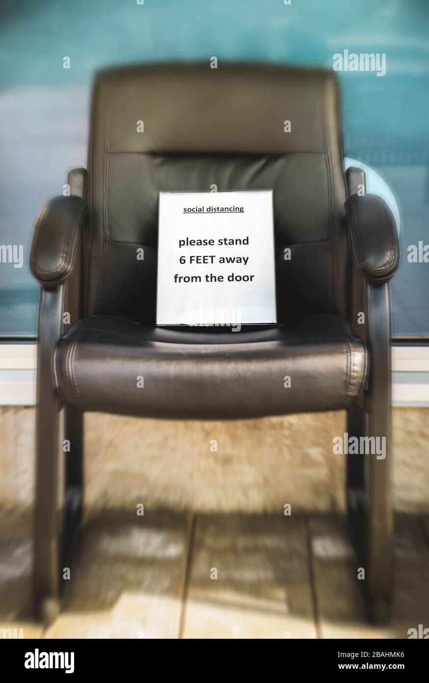 Social and physical distance signs on black office chair outside ...