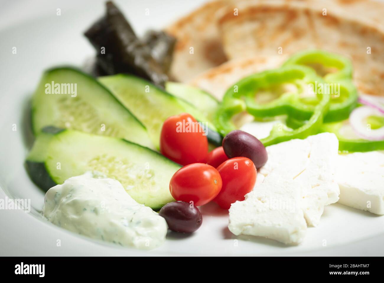 Greek meze food platter; with vegetables, pita, feta, and grape leaves ...