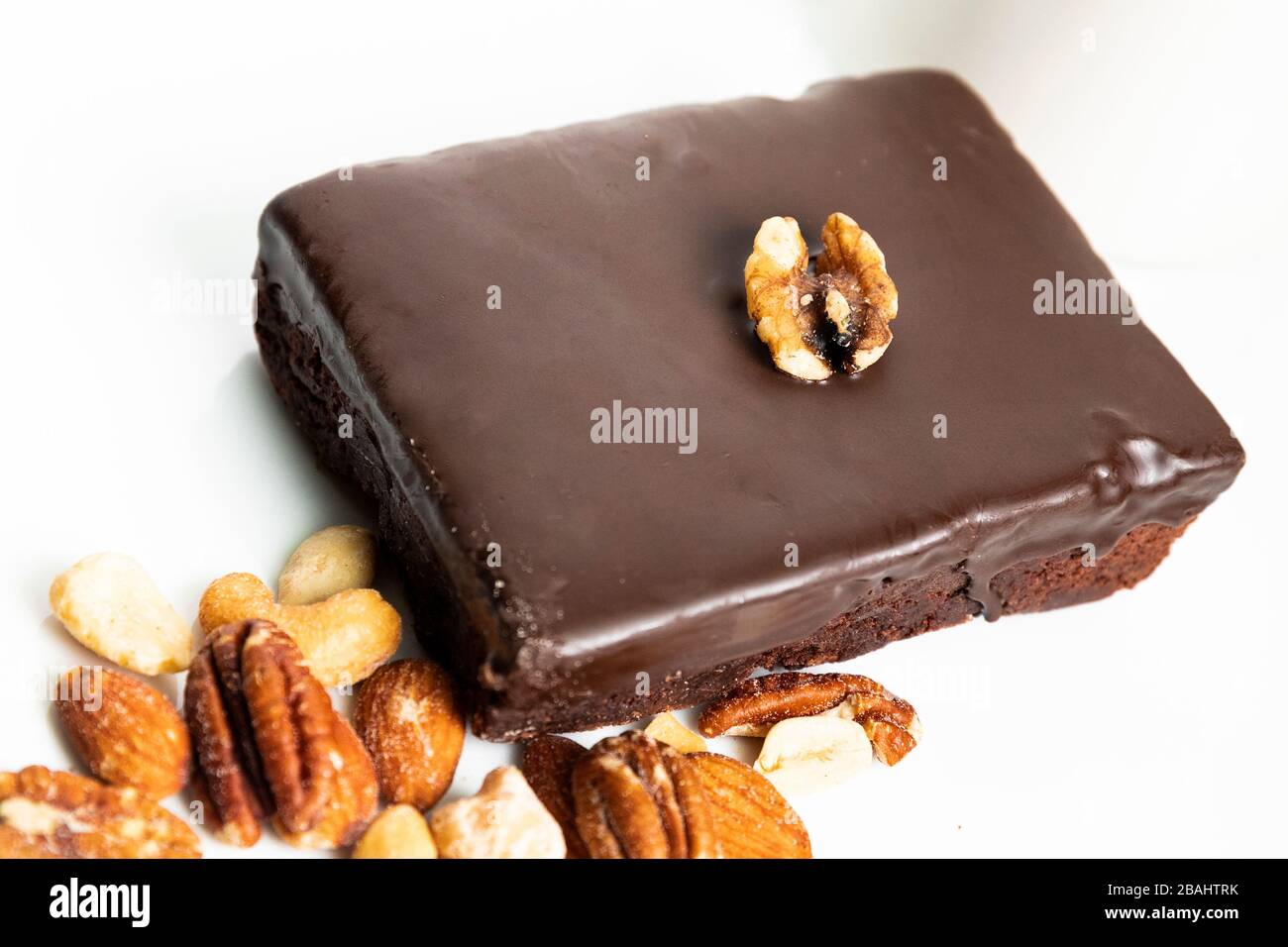 Delicious chocolate fudge brownie and walnut garnish on top; on white ...