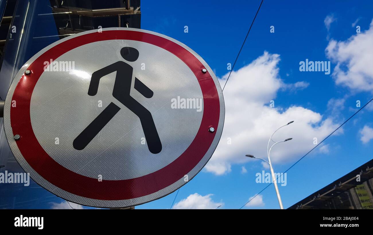 A round road sign of white and red with a black man in the center ...