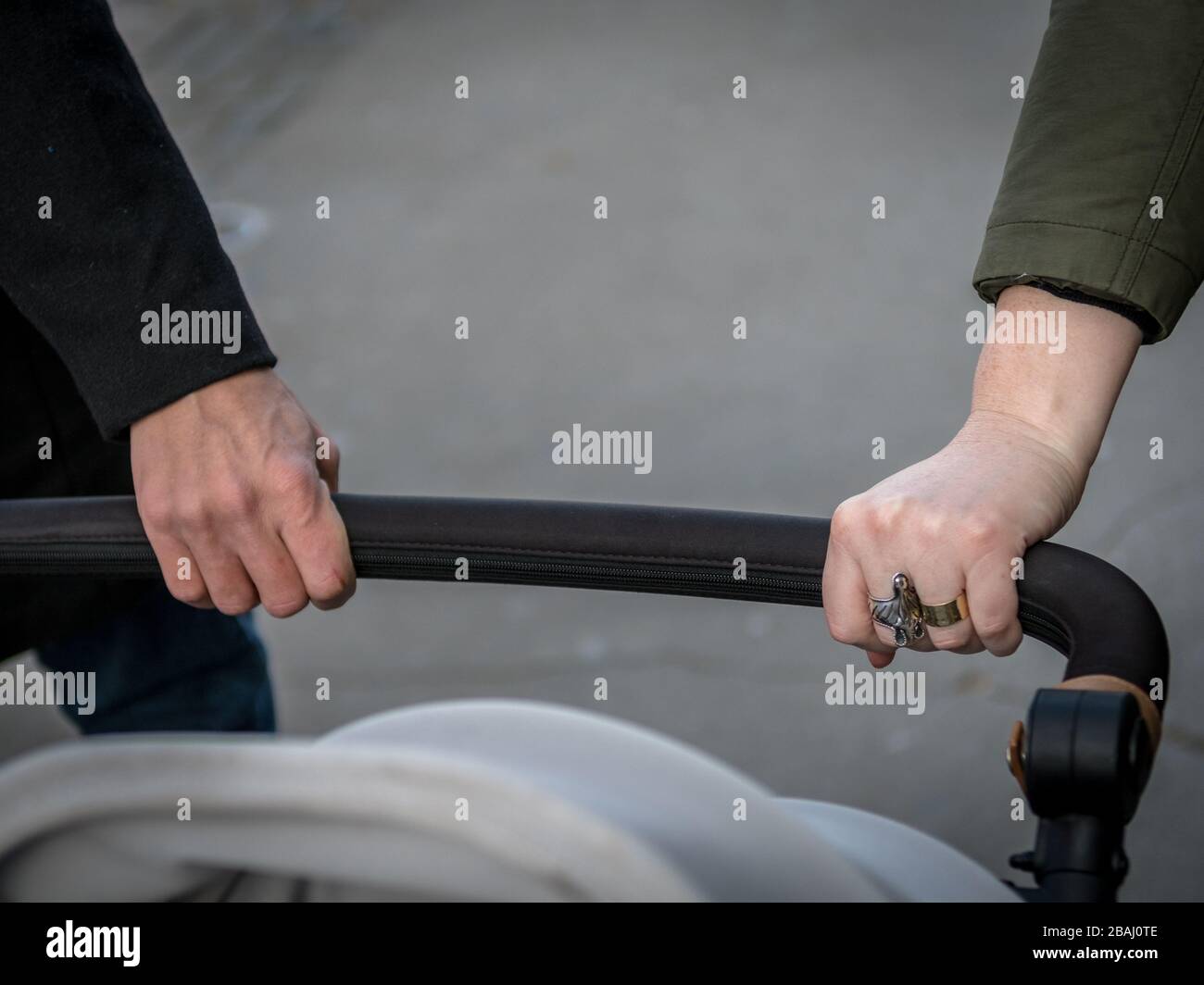 Mother and Father hands pushing a baby stroller together Stock Photo ...