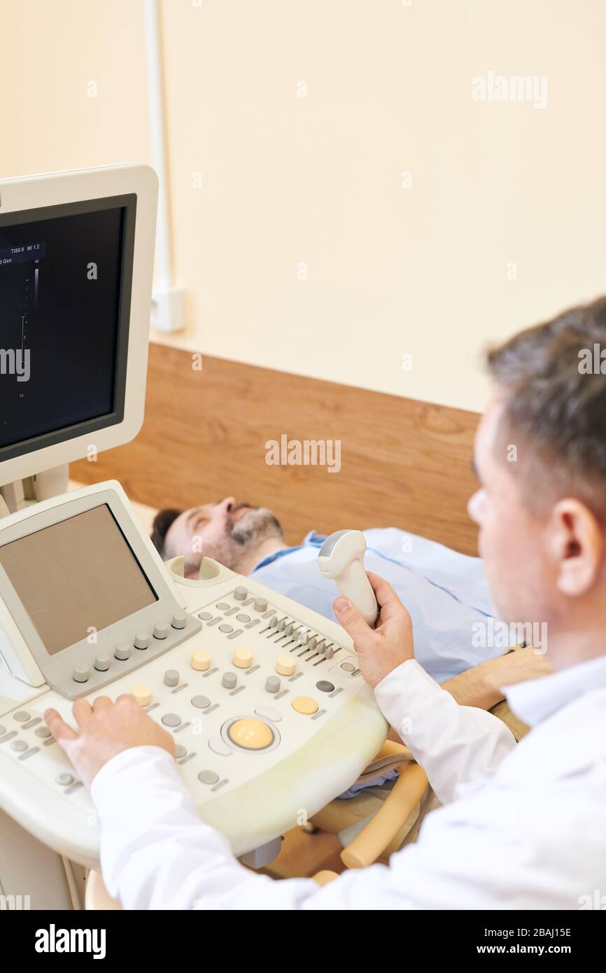 Sonographer looking at ultrasound machine screen and analyzing sizes of ...