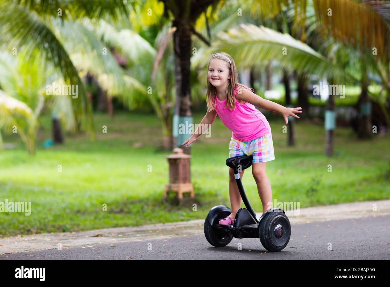 Child on hover board. Kids riding scooter in summer park. Balance board ...