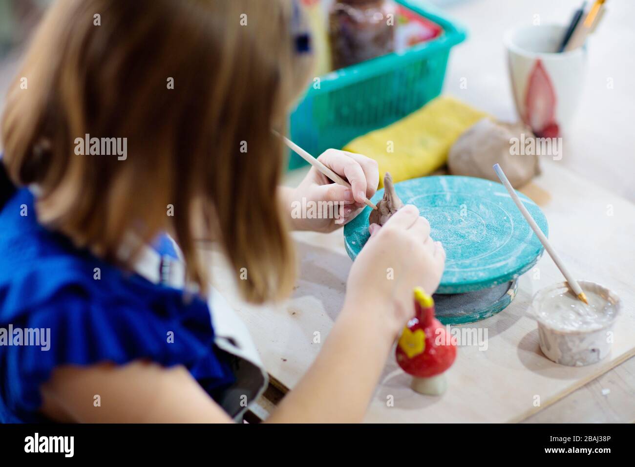 Child working on pottery wheel. Kids arts and crafts class in workshop ...