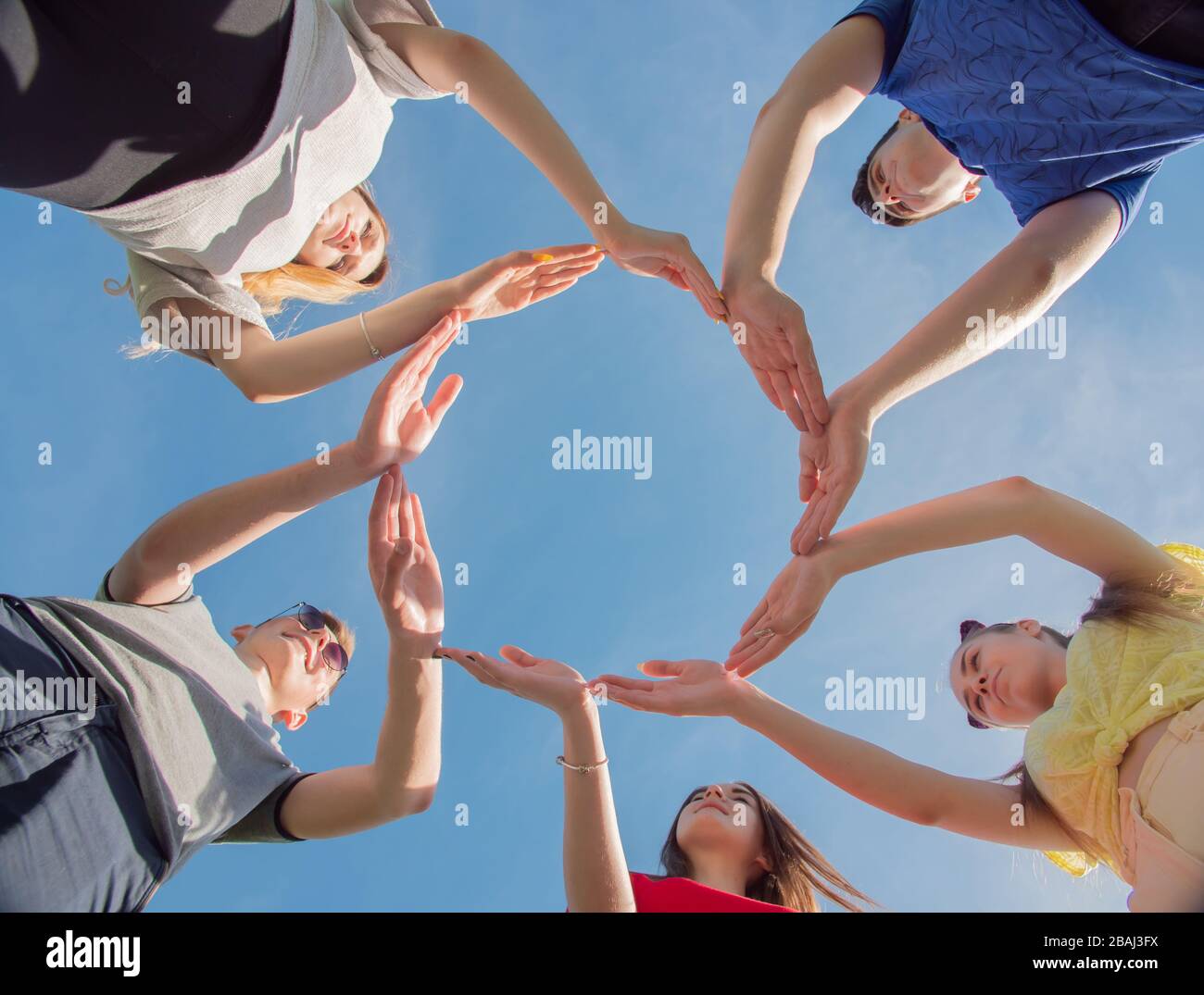 A group of friends makes a circle from the palms of their hands Stock ...