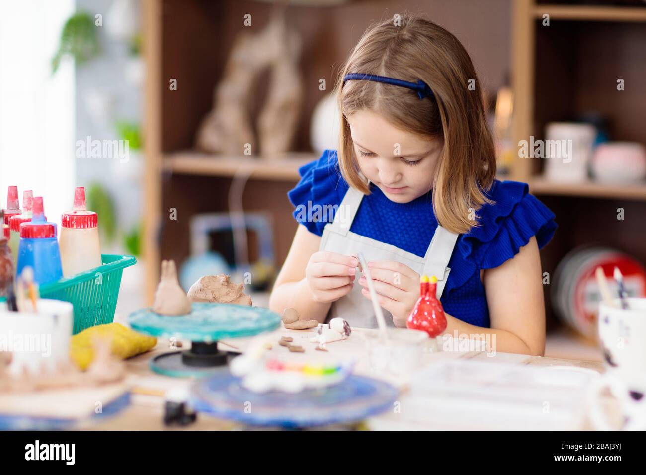 Child working on pottery wheel. Kids arts and crafts class in workshop ...