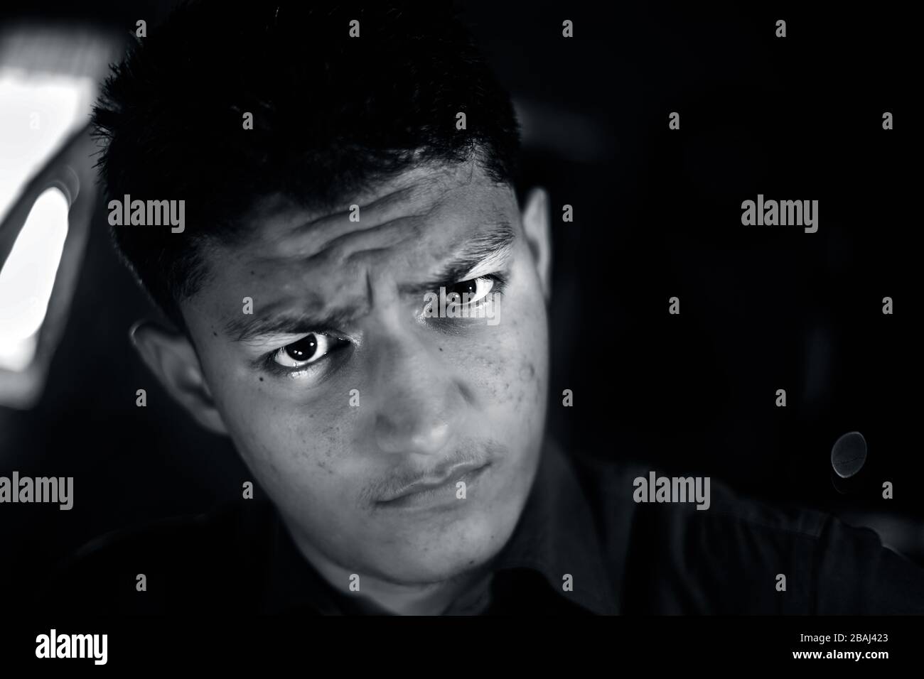 Portrait shot of a tried exhausted male in the serious asking pose ...