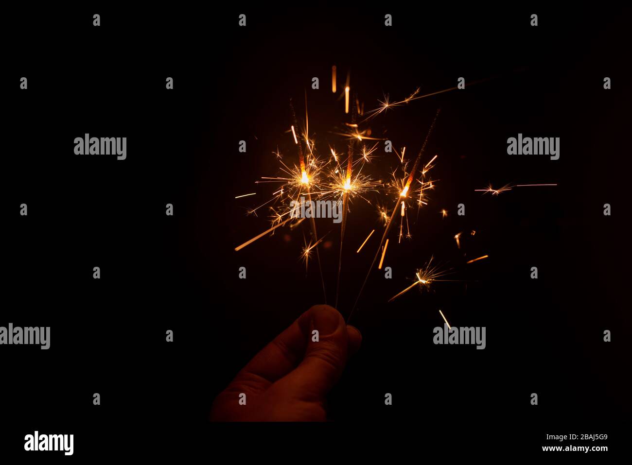Sparklers shining bright in dark room Stock Photo - Alamy