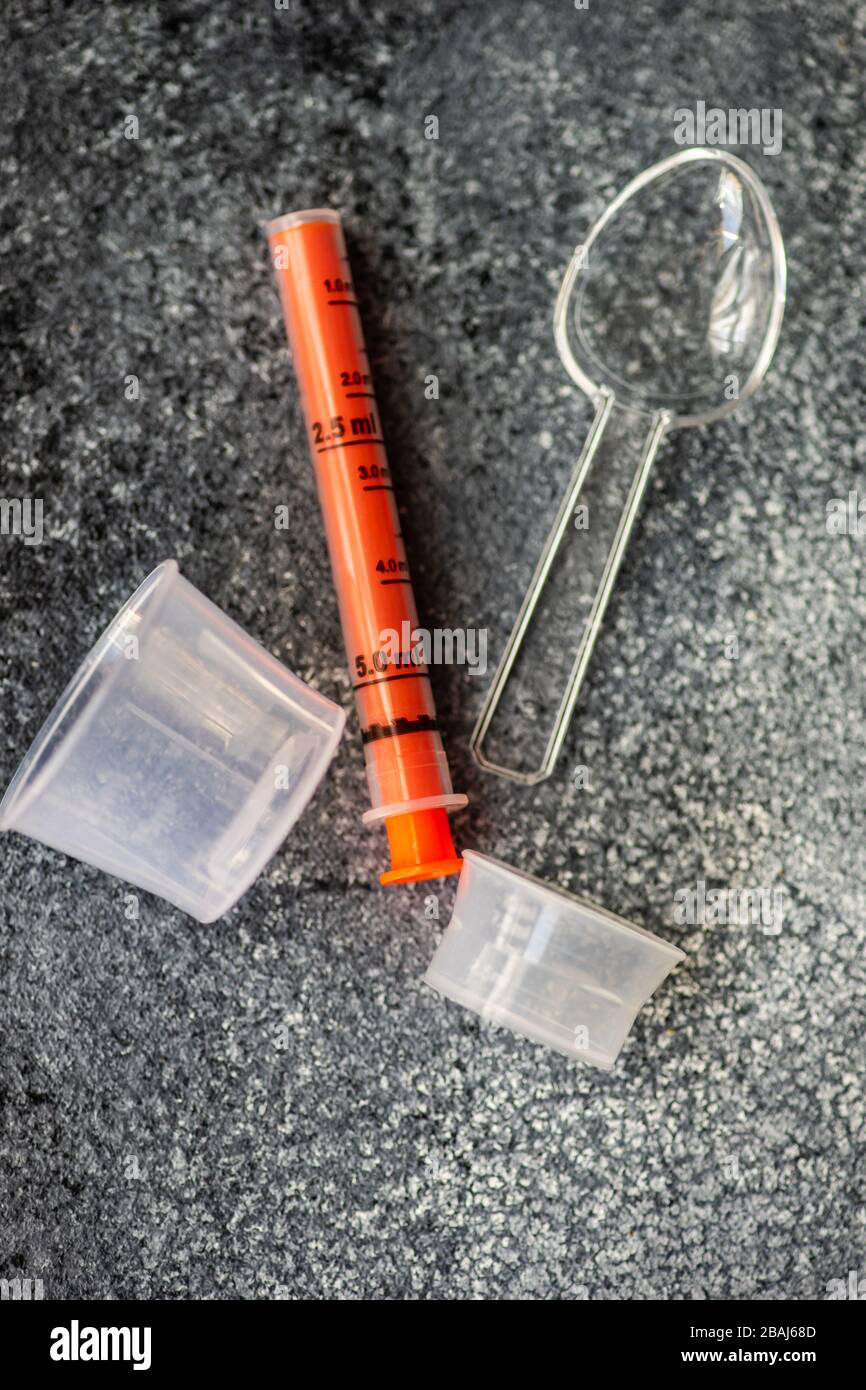 Measuring spoons, bowl and syringe on stone background as a Covid-19 ...