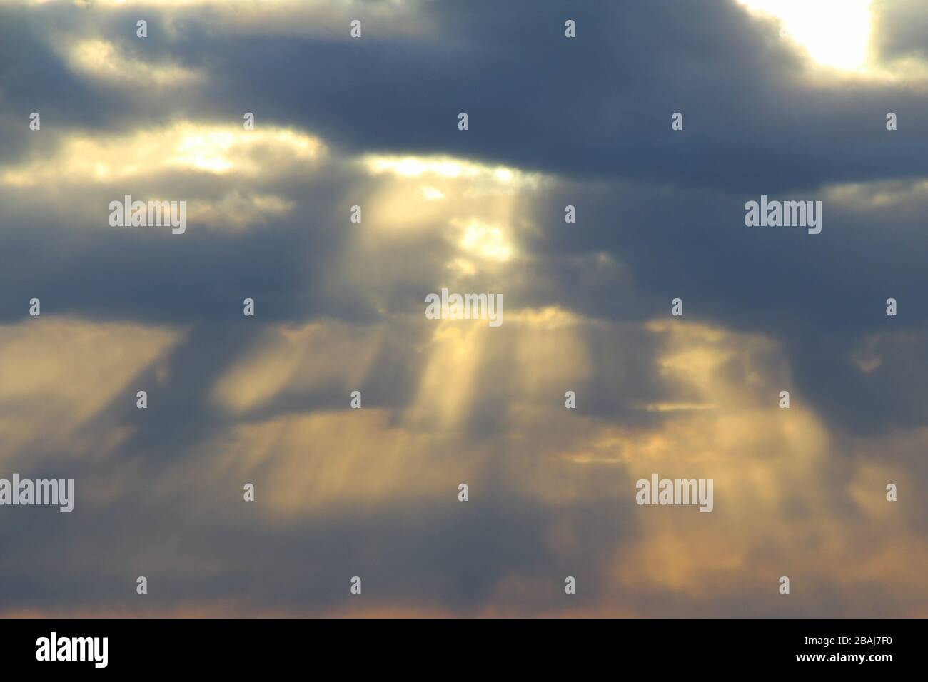 The sun at sunset or dawn behind the clouds, shines through. The sun's ...