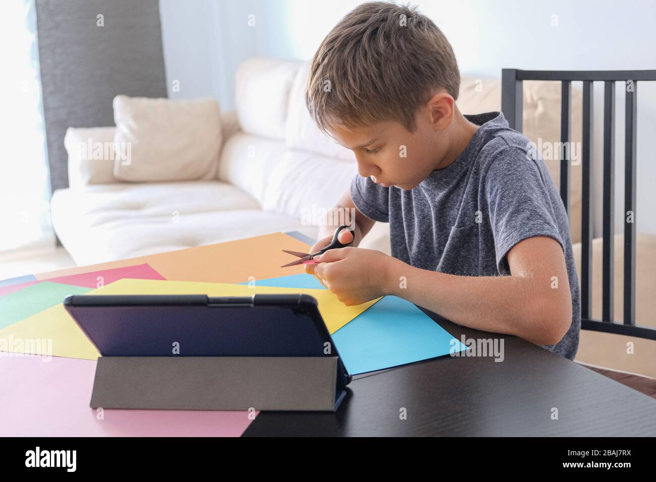 Paper crafts for kids. Child cutting colored paper with scissors. Boy ...