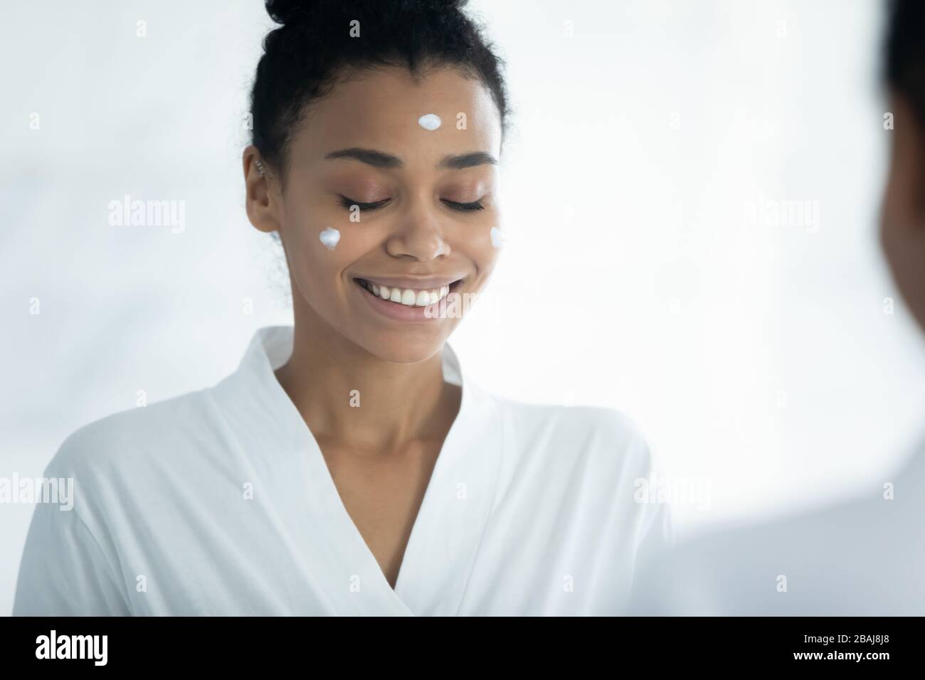 African woman applied facial cream doing skincare procedures at home ...