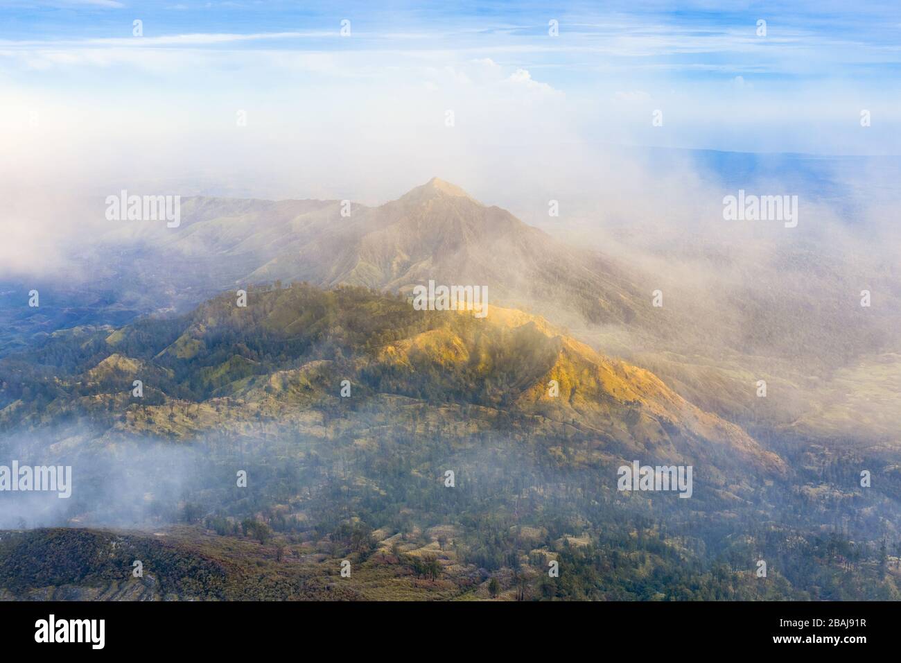 Stunning aerial view of a beautiful mountain range surrounded by clouds ...