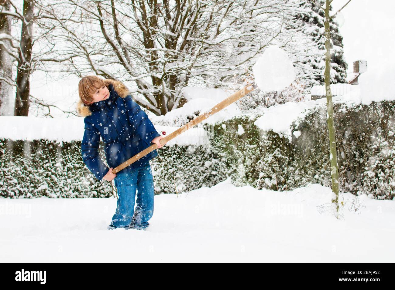Child shoveling snow. Little boy with spade clearing driveway after ...
