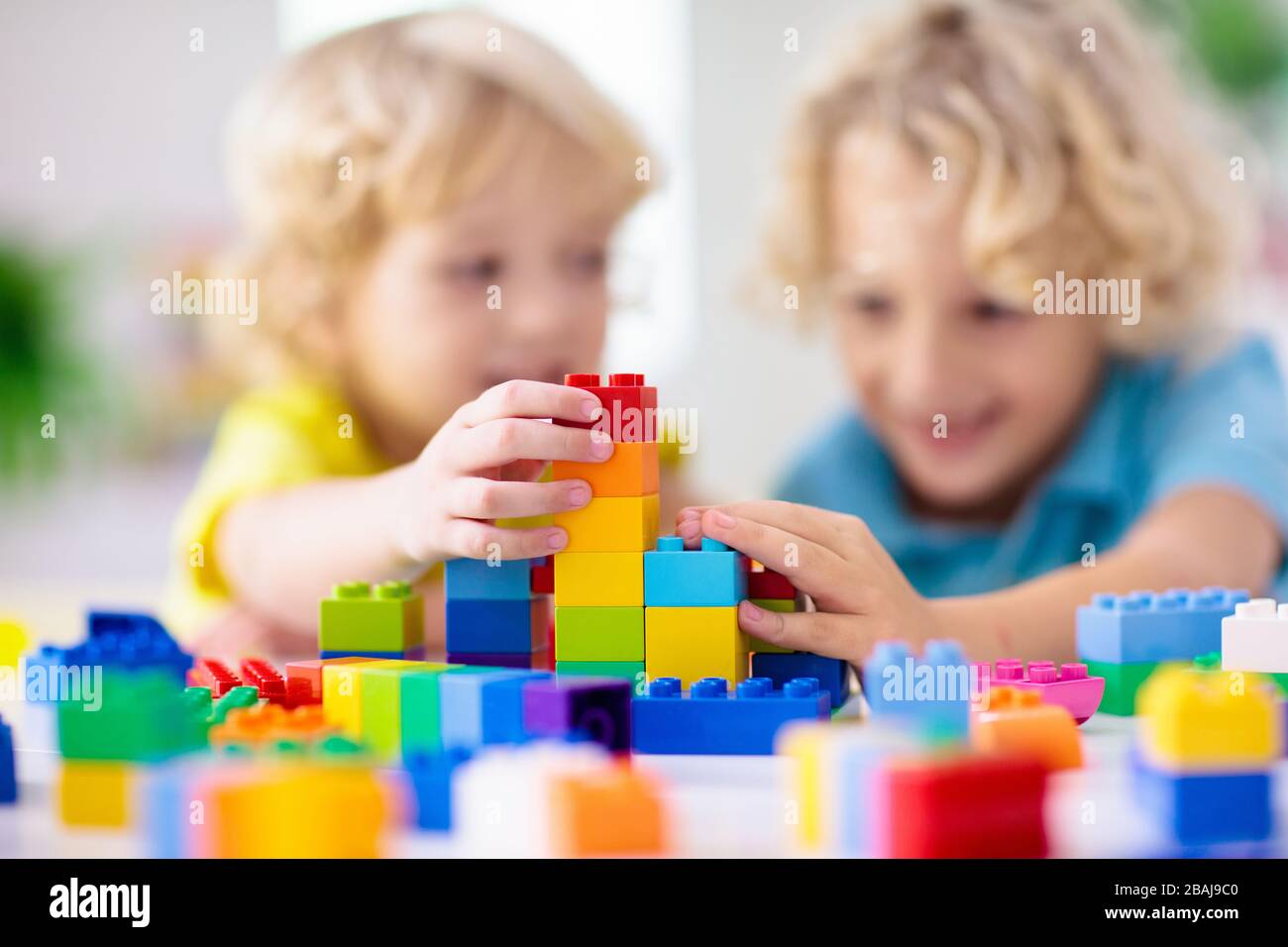 Kids play with colorful blocks. Little boy building tower at home or ...