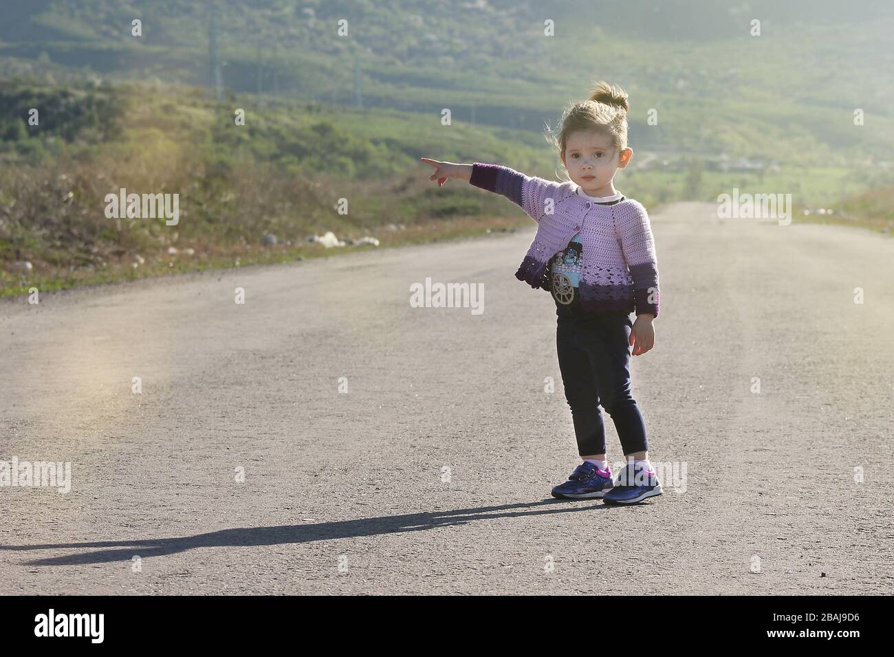 Escape children from the house - little girl hitchhiking on the road ...