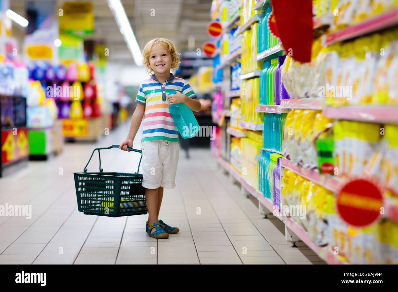 Child in supermarket buying fruit and juice. Kid grocery shopping ...