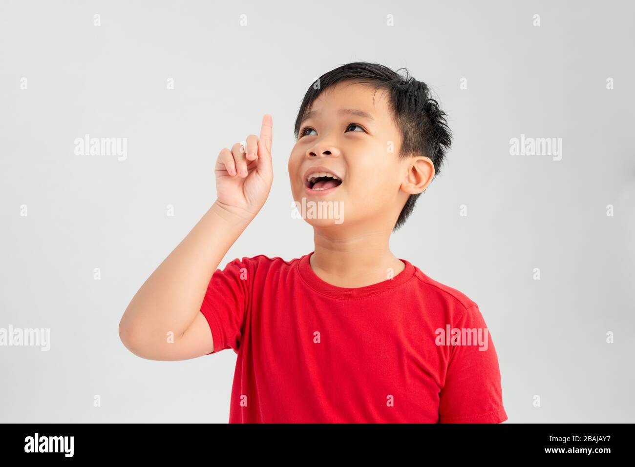 Cheerful little boy pointing up over white background Stock Photo - Alamy