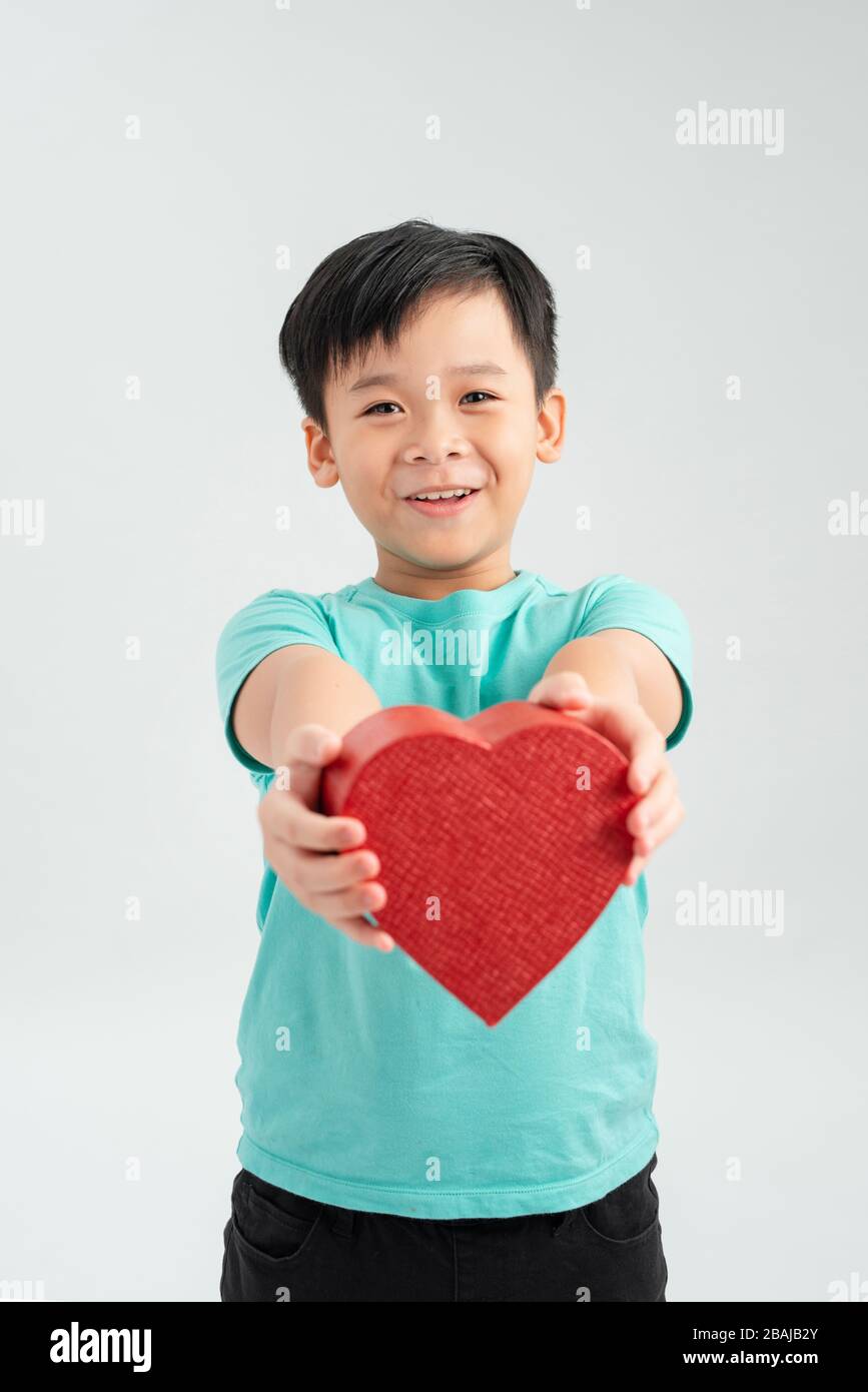 Happy boy in love holding heart shaped gift box Stock Photo - Alamy