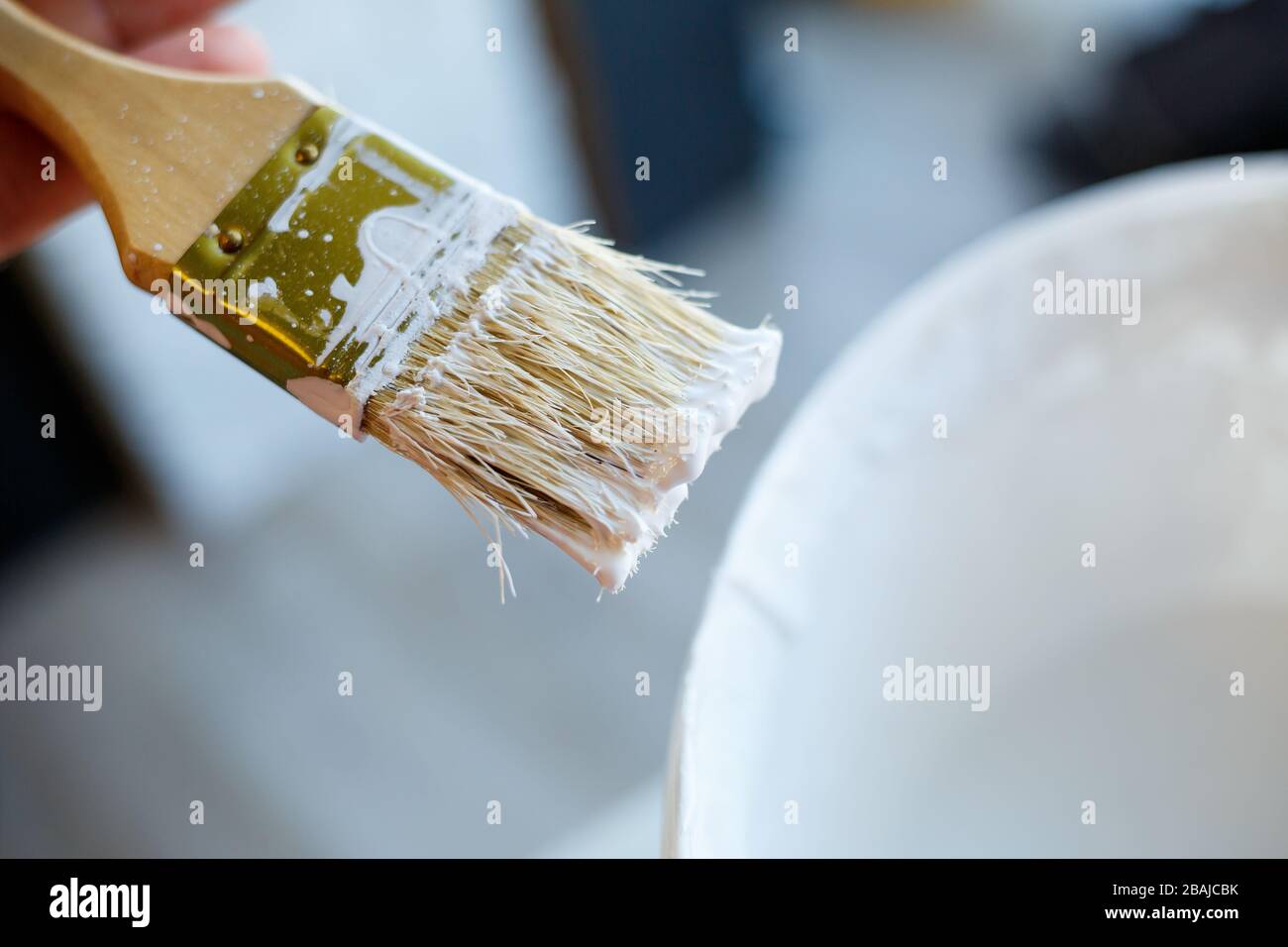 Paint brush in a bucket with white paint Stock Photo - Alamy