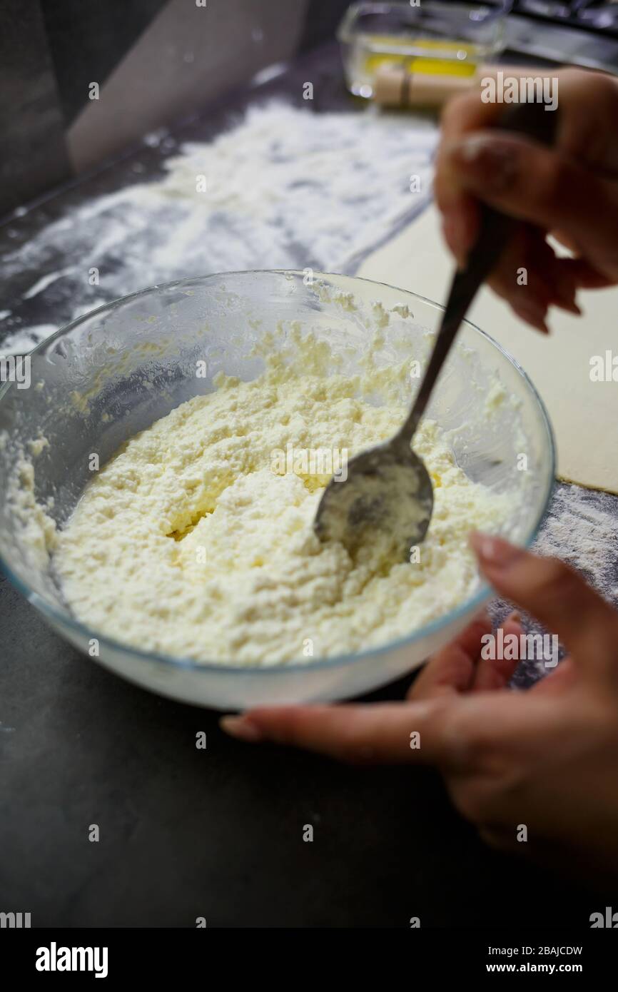 Baking domestic rolls with cheese. Putting cheese on dough for rolls ...