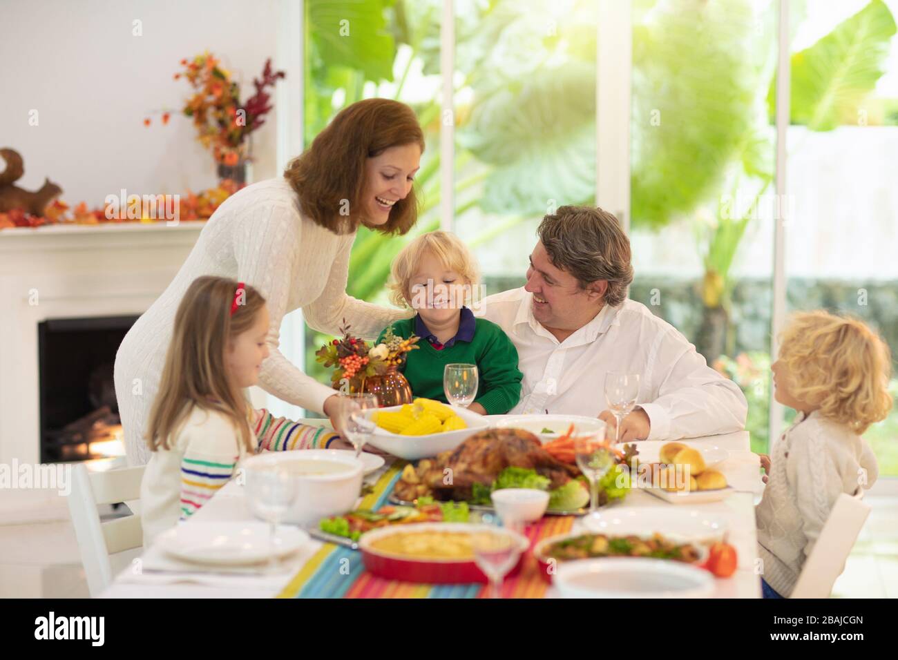Family with kids eating Thanksgiving dinner. Roasted turkey and pumpkin ...
