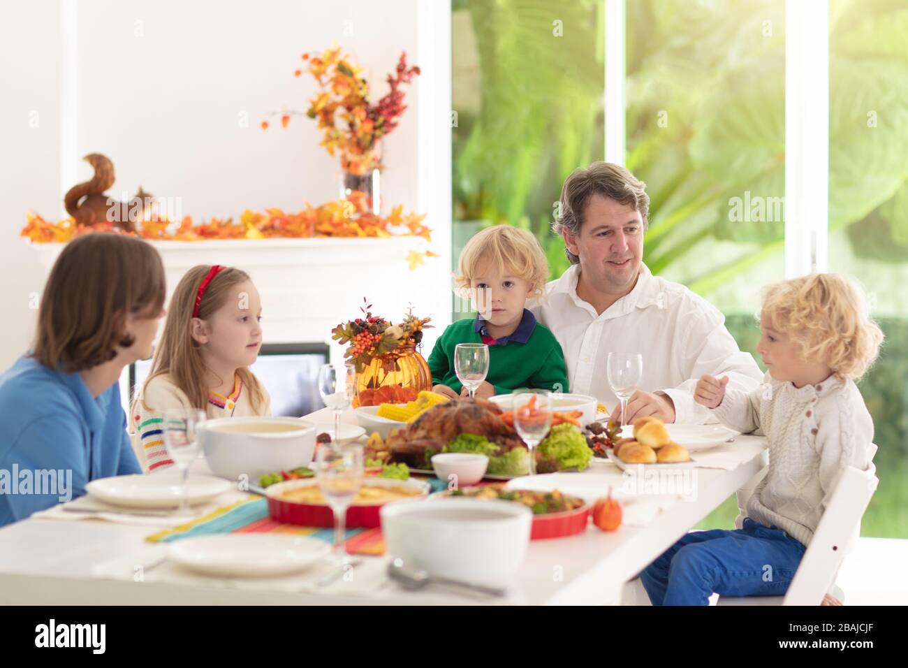 Family with kids eating Thanksgiving dinner. Roasted turkey and pumpkin ...