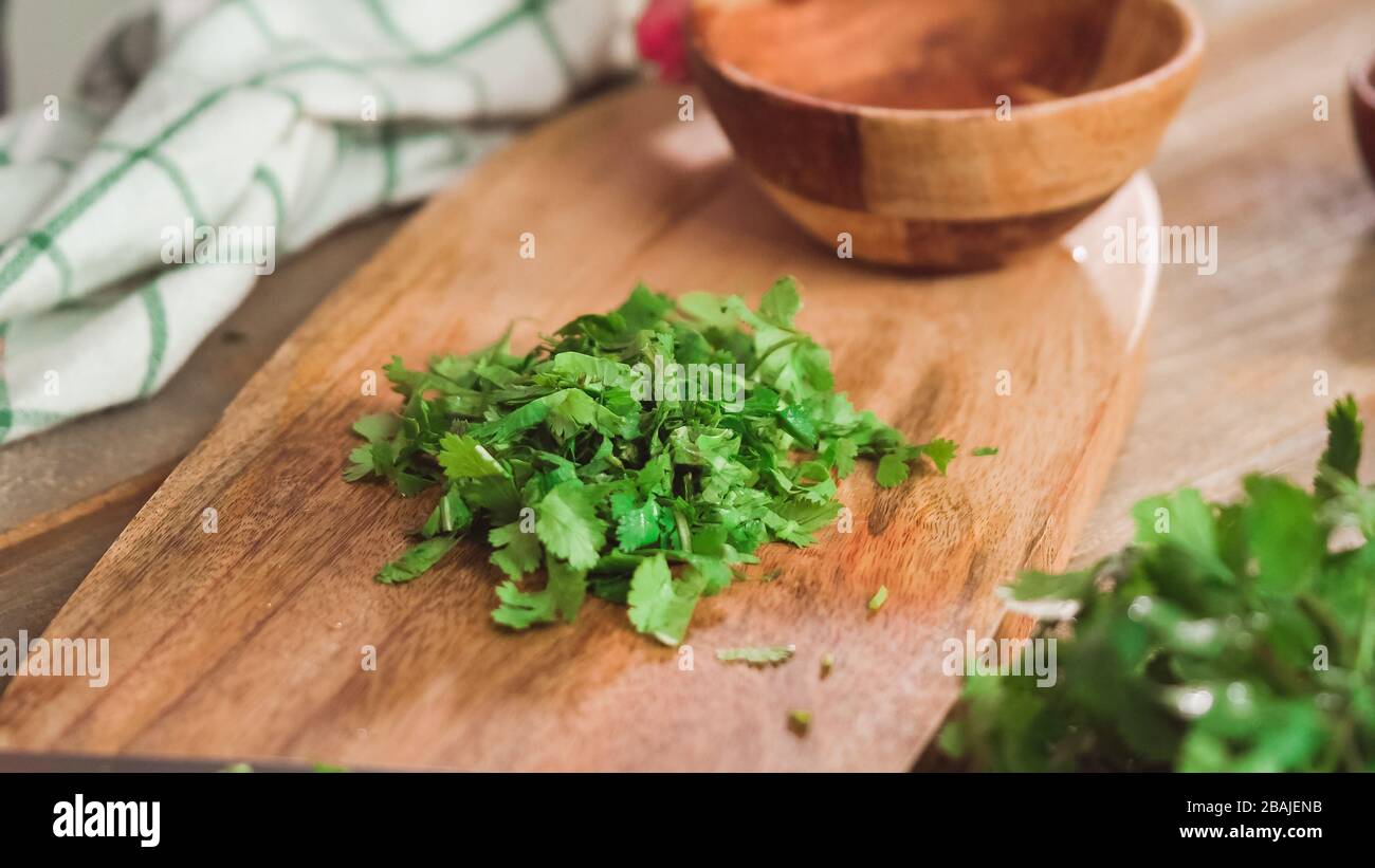 Cutting organic parsley on a wood cuttig board Stock Photo - Alamy