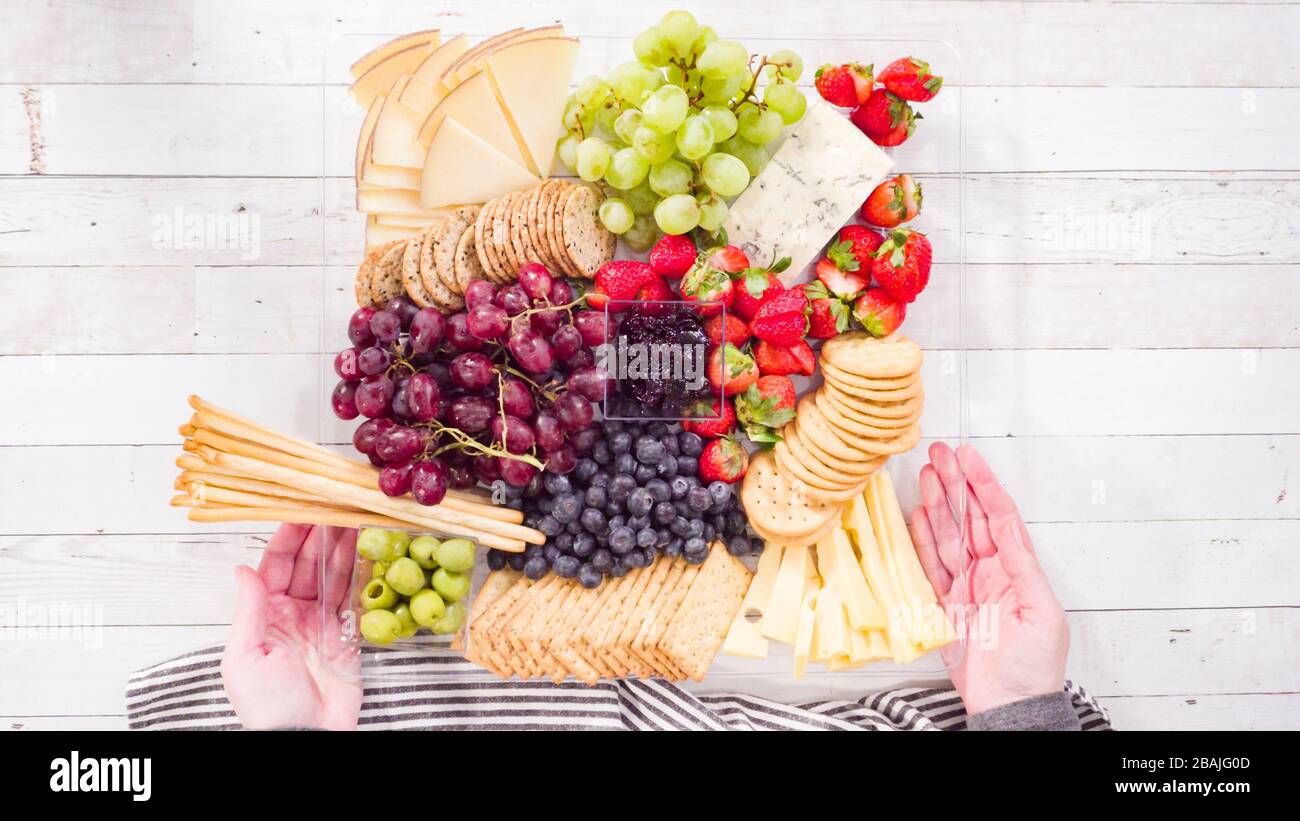 Flat lay. Step by step. Arranging cheese platter with fresh fruits ...