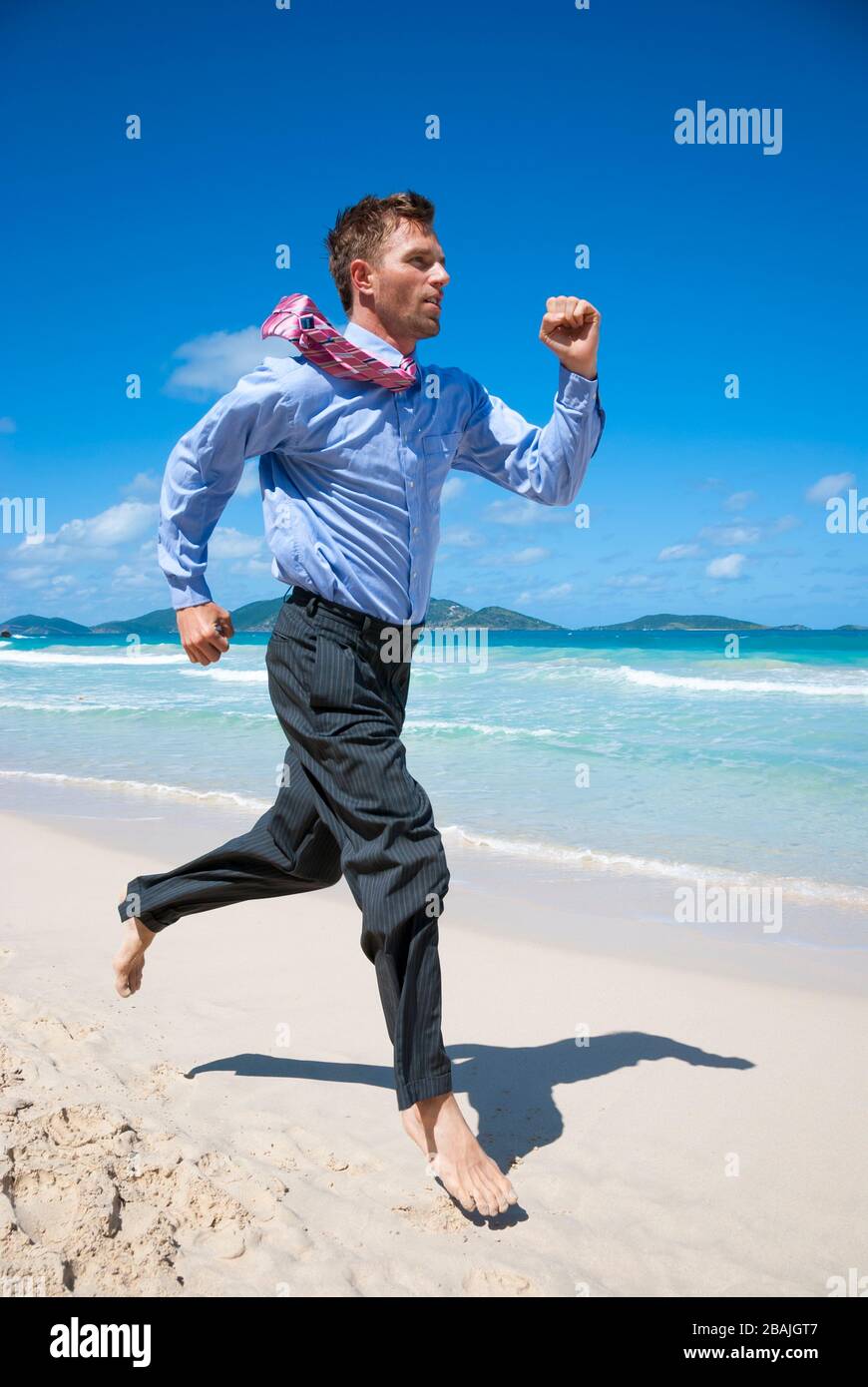 Barefoot businessman running along an empty tropical beach Stock Photo ...