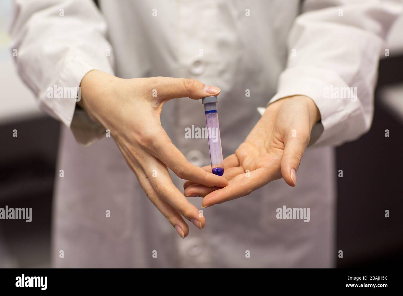 Woman lab technician holding test tube Stock Photo - Alamy
