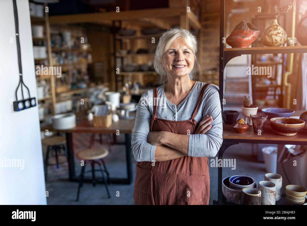 Portrait of senior female pottery artist in her art studio Stock Photo ...