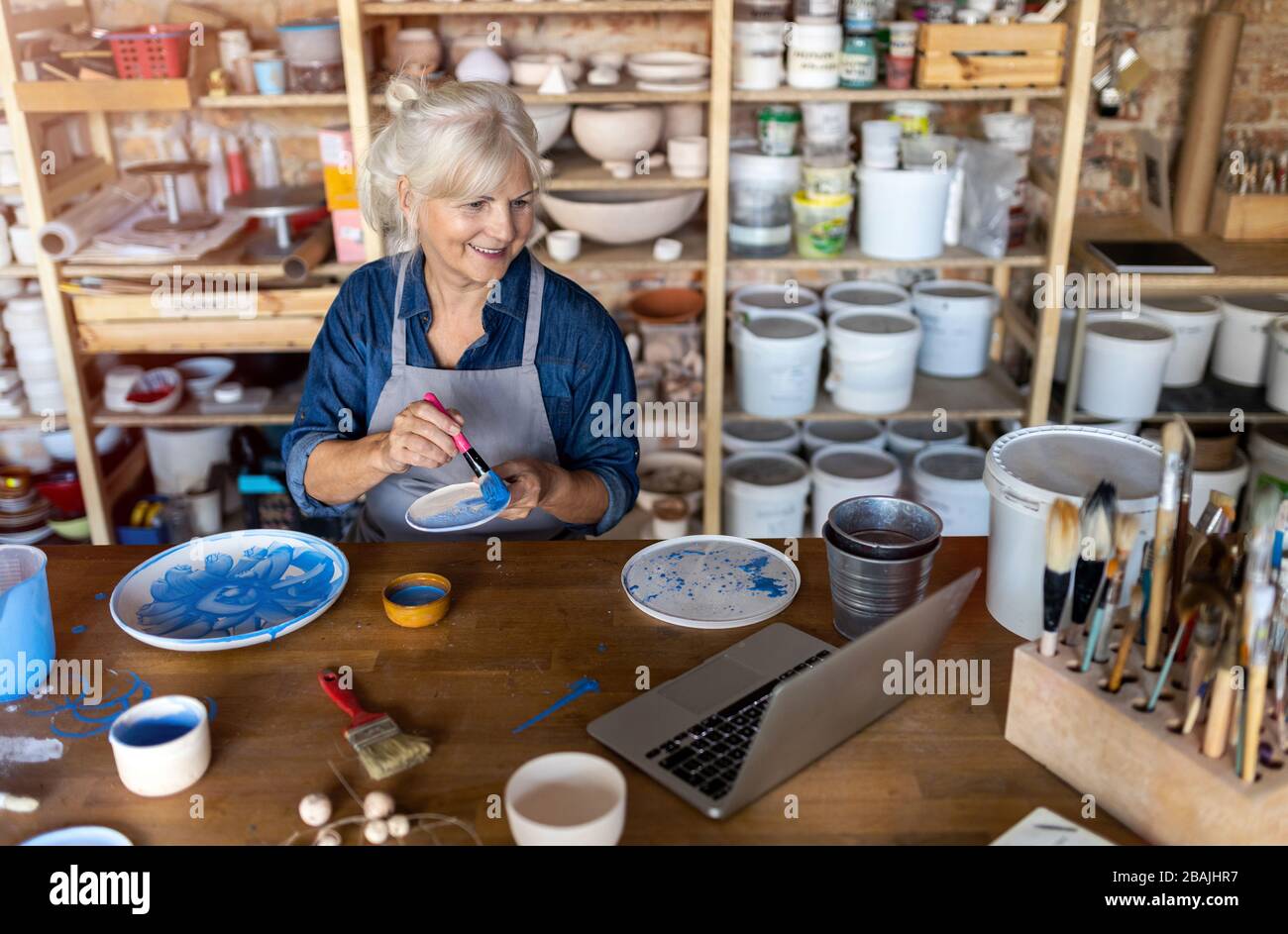 Portrait of senior female pottery artist in her art studio Stock Photo ...