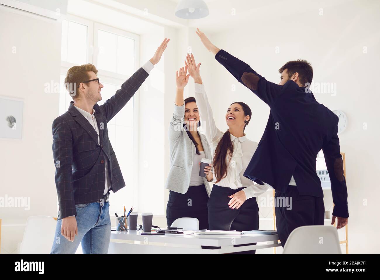 Group of business people standing smiling raised their hands up happy ...