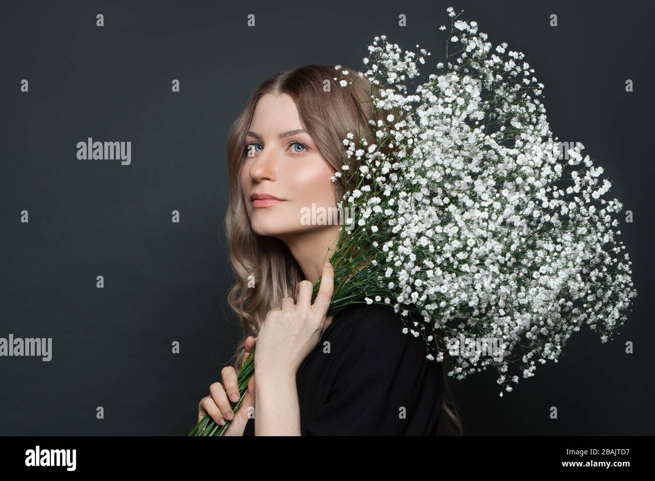 Beautiful woman with white flowers reminiscing and dreaming on black ...
