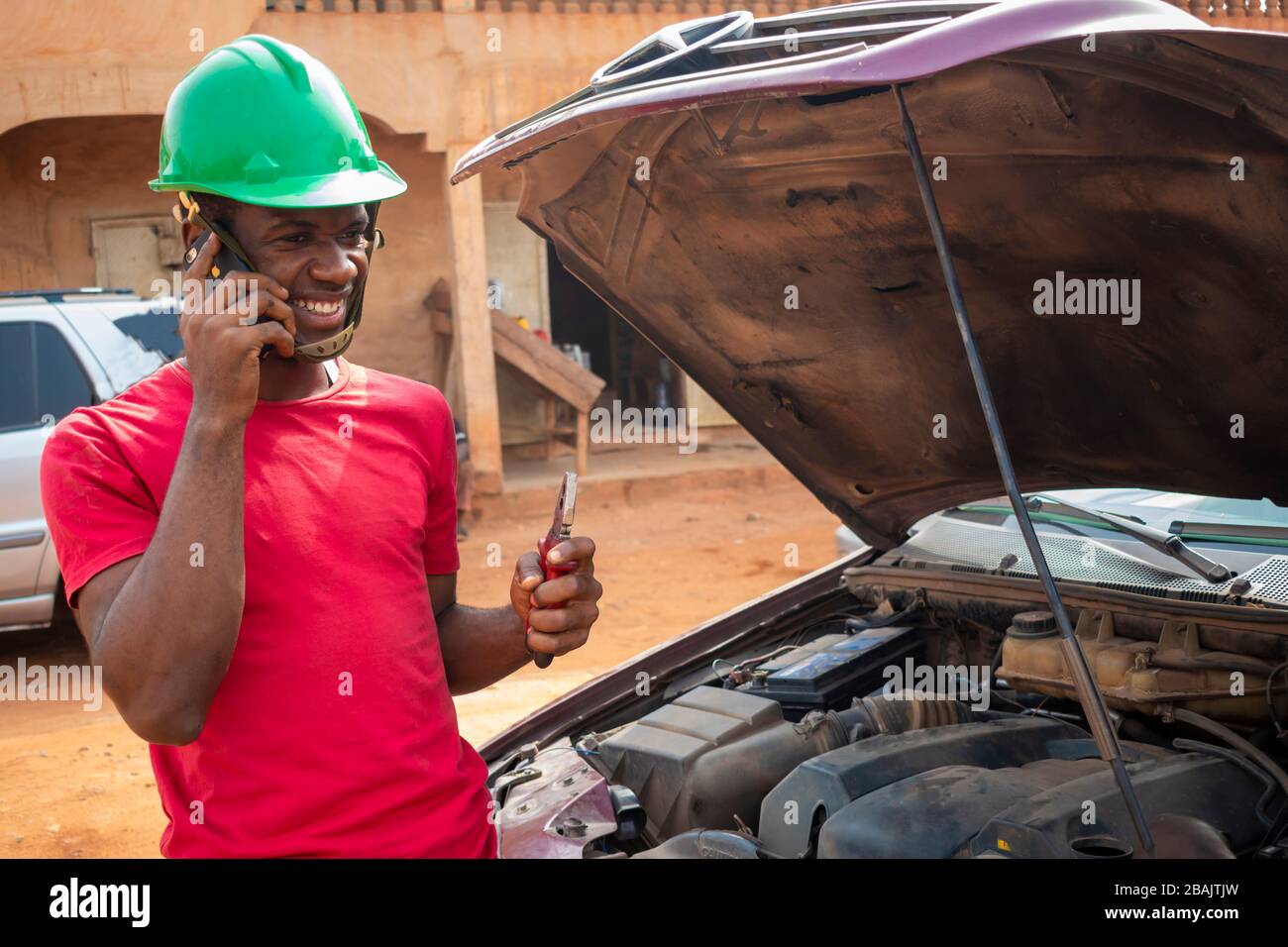 a young african engineer making a phone call as he's working on a ...