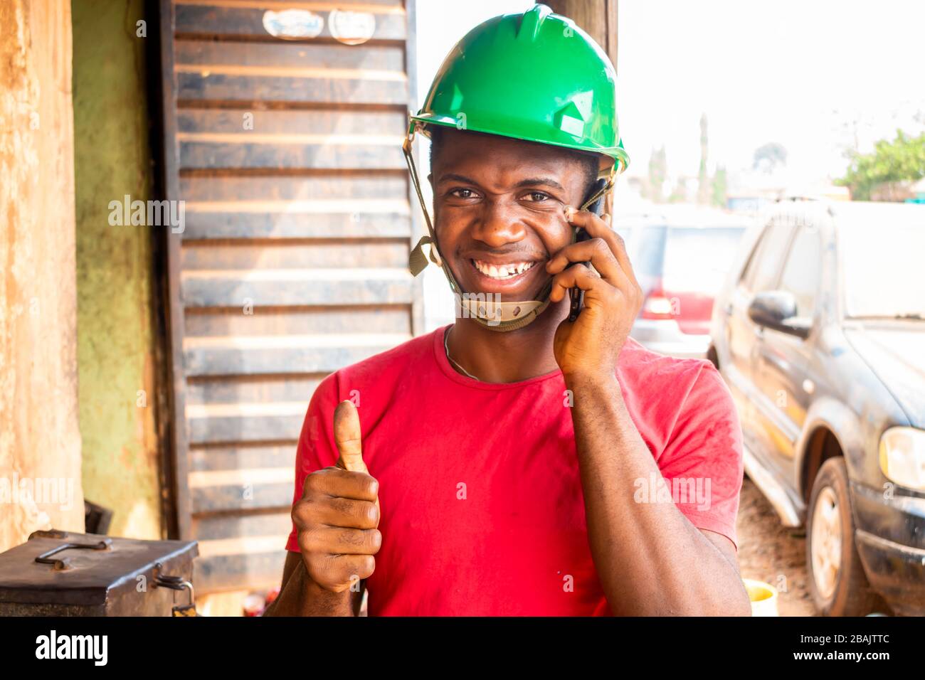 a young african engineer making a phone call in his place of work and ...