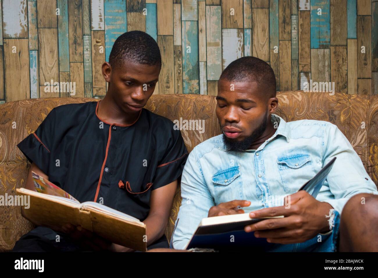 two black african seriously student studying their school work against ...