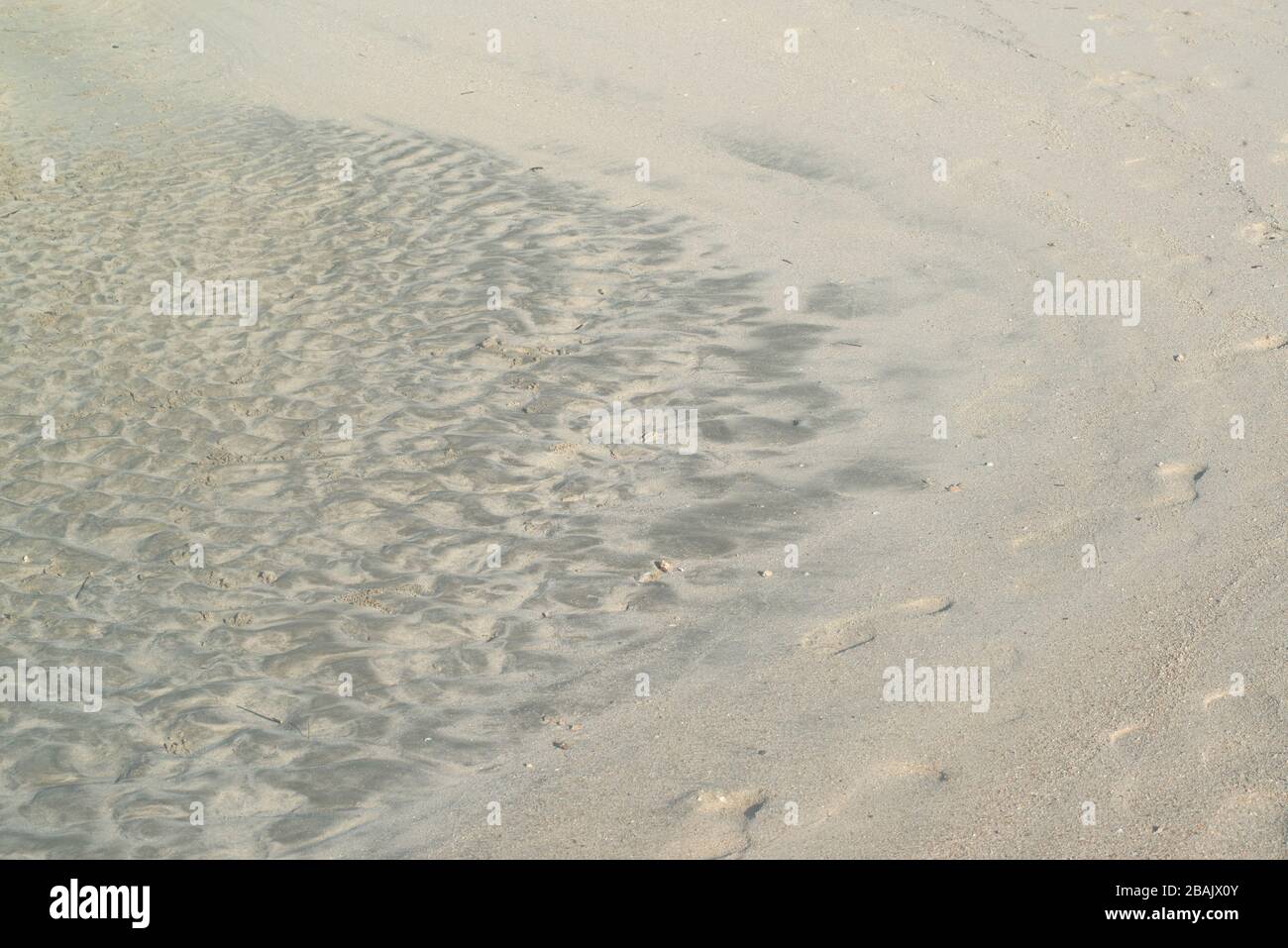 Sand rippled textured pattern and background created by low tide on a ...