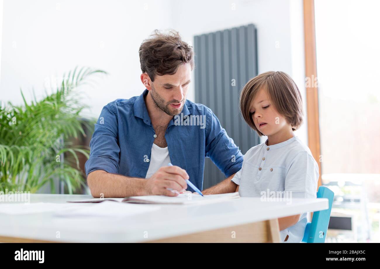 Father and son doing homework together at home Stock Photo - Alamy