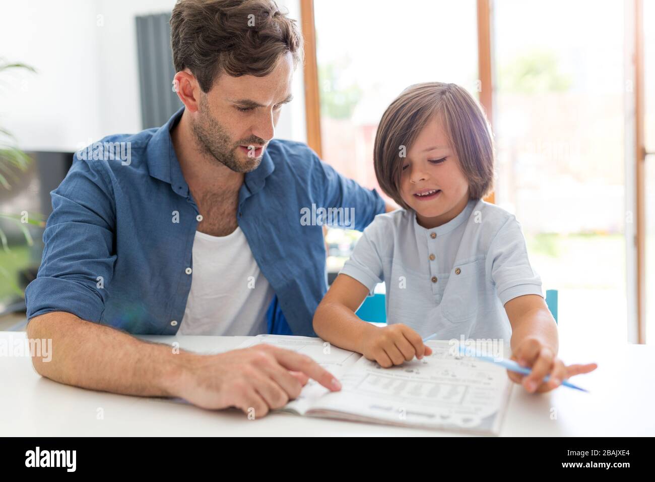 Father and son doing homework together at home Stock Photo - Alamy