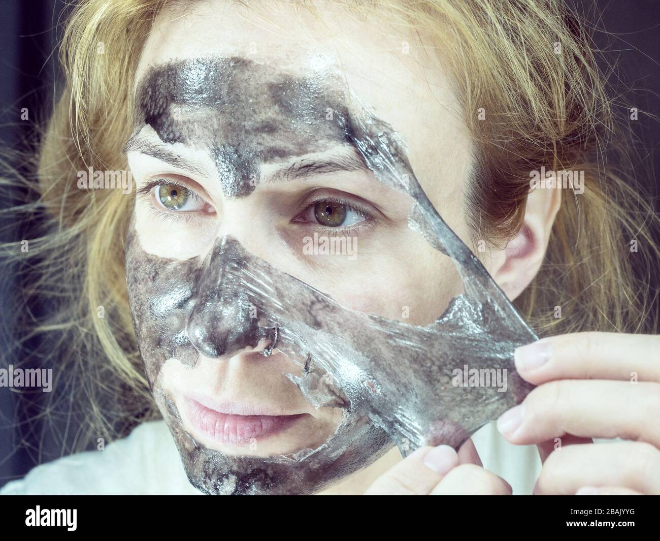 Close-up photo of girl removing black thin mask from her face Stock ...