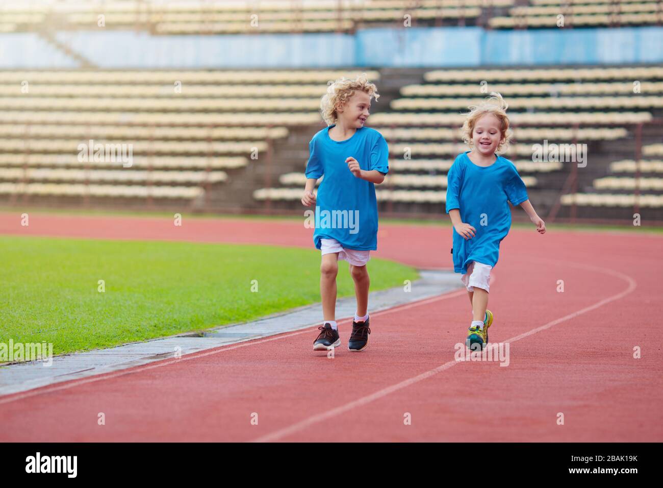 Child running in stadium. Kids run on outdoor track. Healthy sport ...