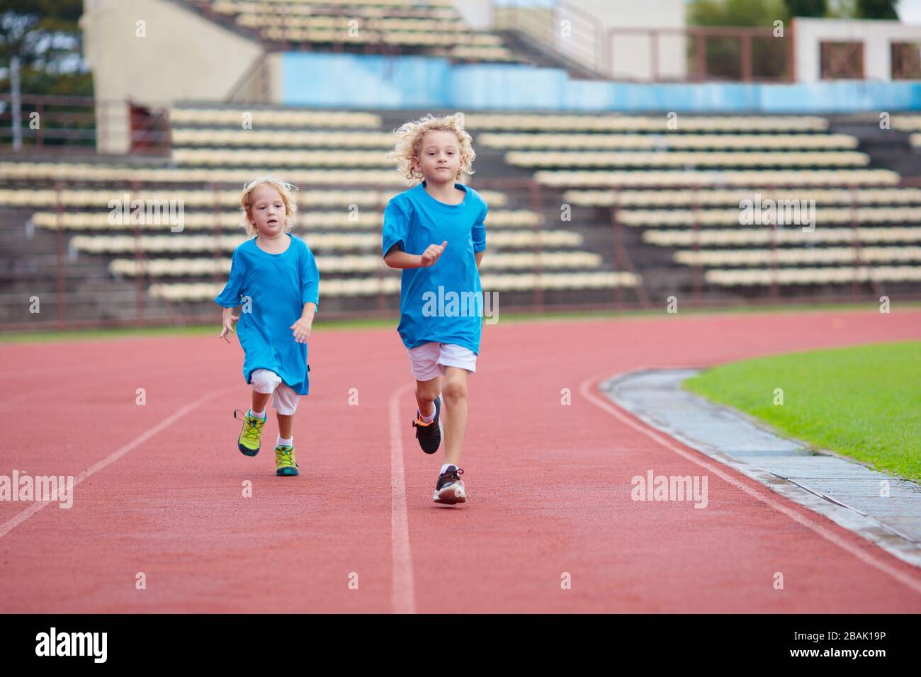 Child running in stadium. Kids run on outdoor track. Healthy sport ...