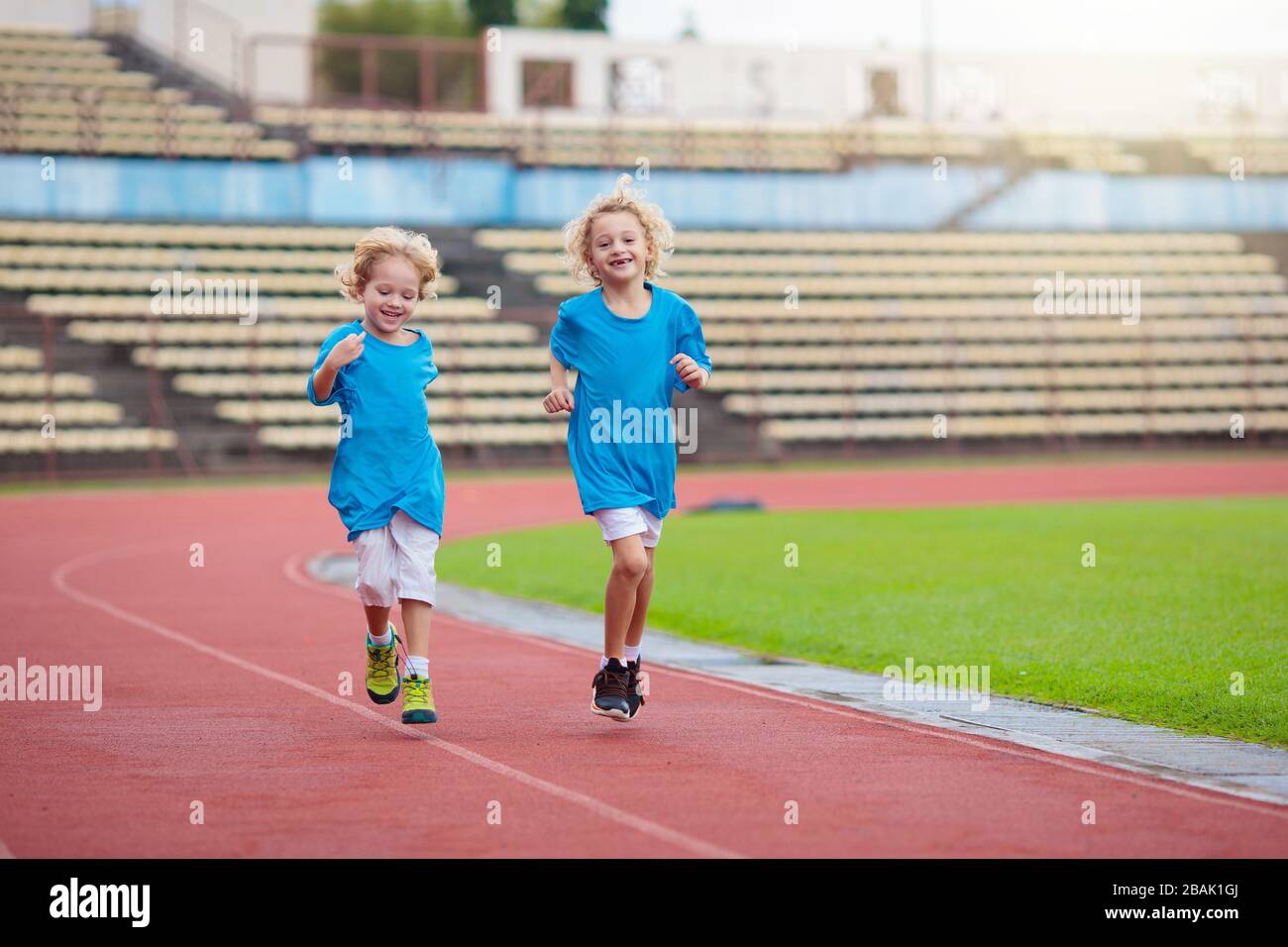 Child running in stadium. Kids run on outdoor track. Healthy sport ...