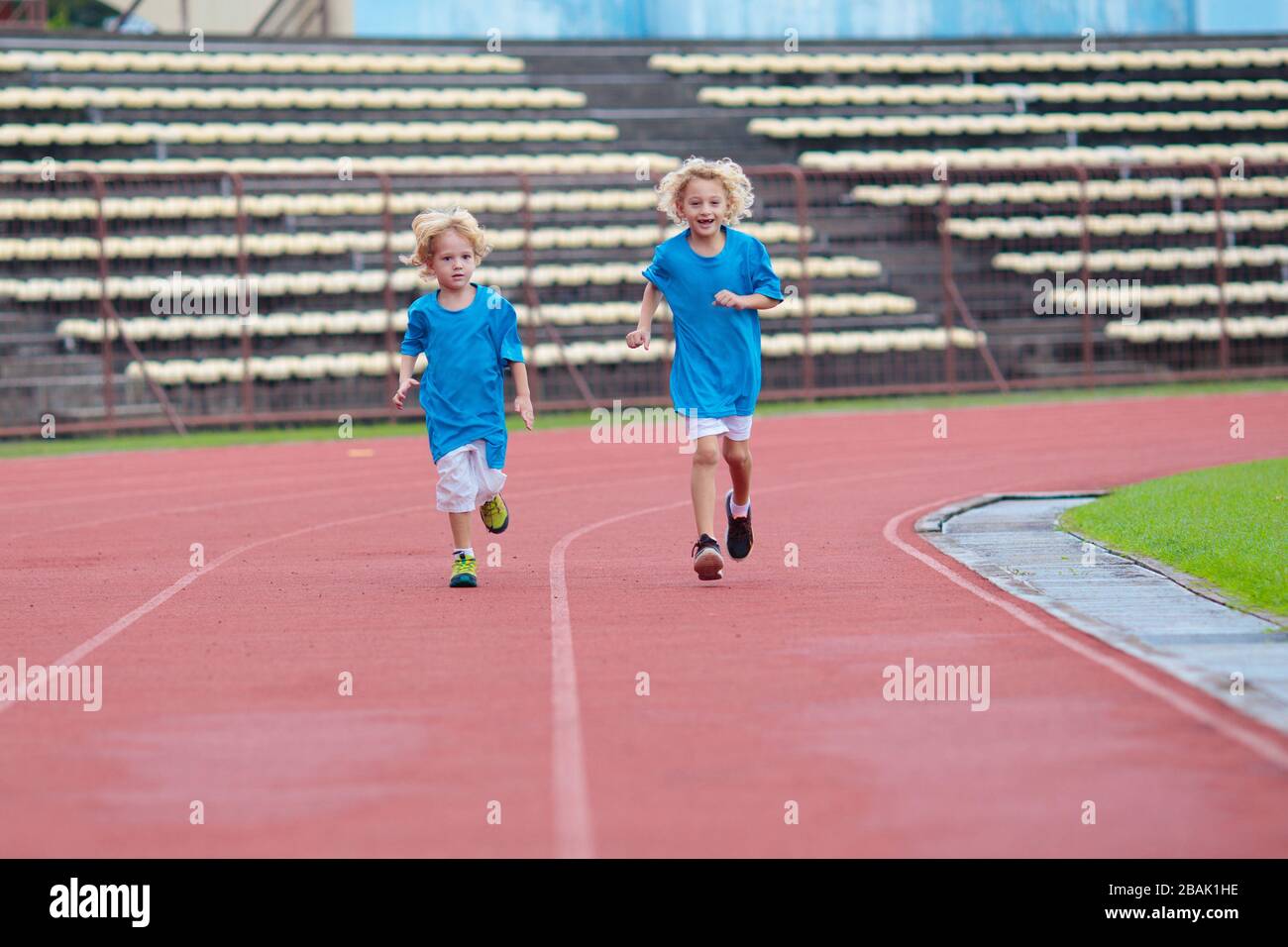 Child running in stadium. Kids run on outdoor track. Healthy sport ...