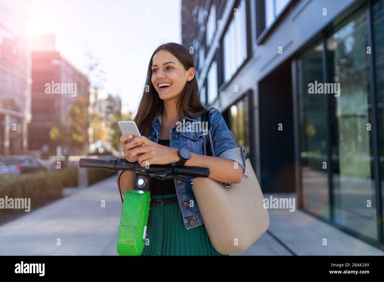 Female commuter riding electric push scooter Stock Photo - Alamy