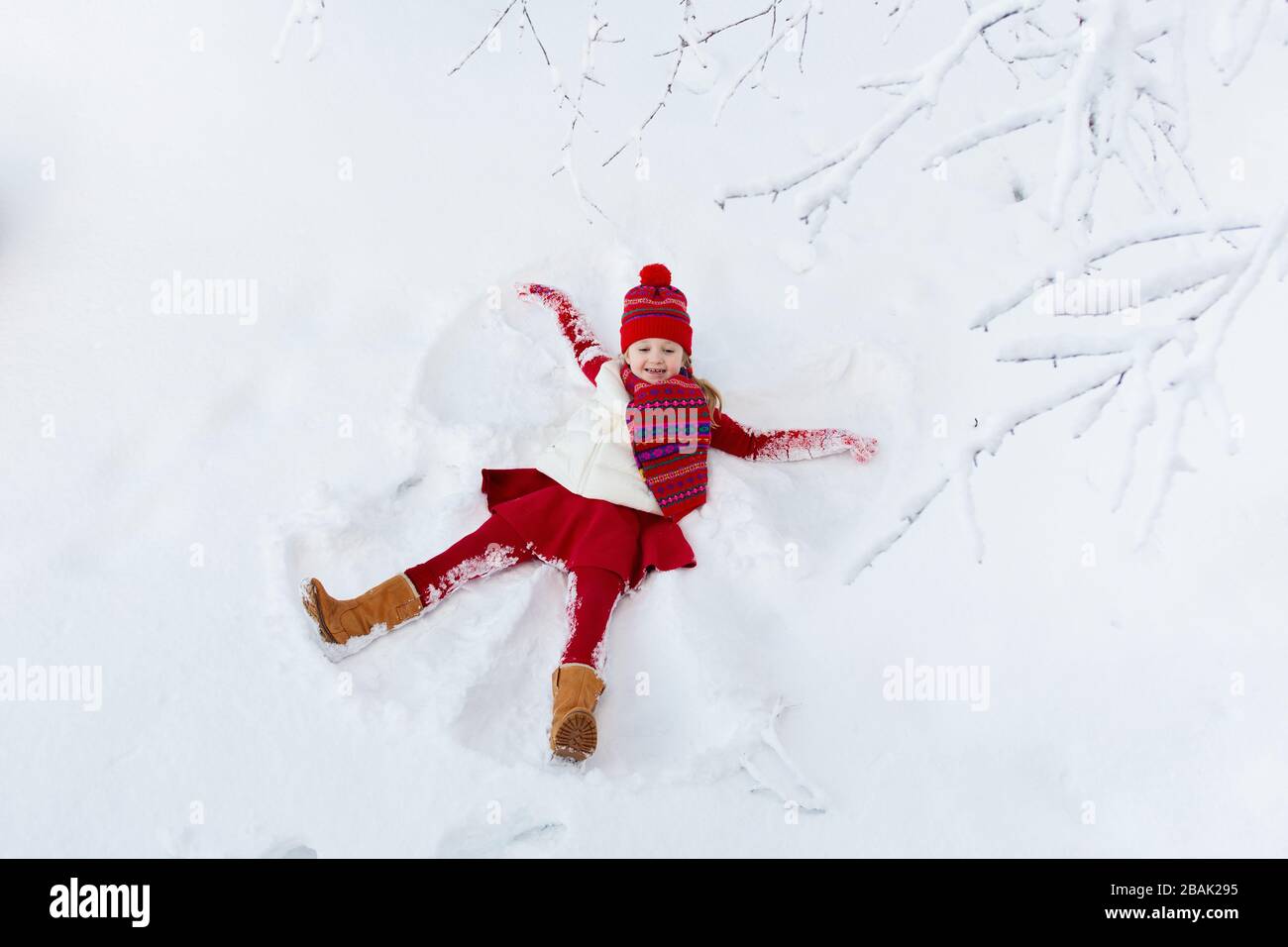 Child making snow angel on sunny winter morning. Kids winter outdoor ...